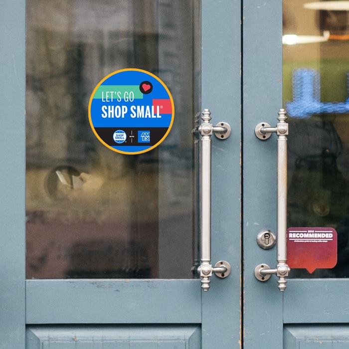 Amex-branded round window cling stating Let's Go Shop Small applied to ...